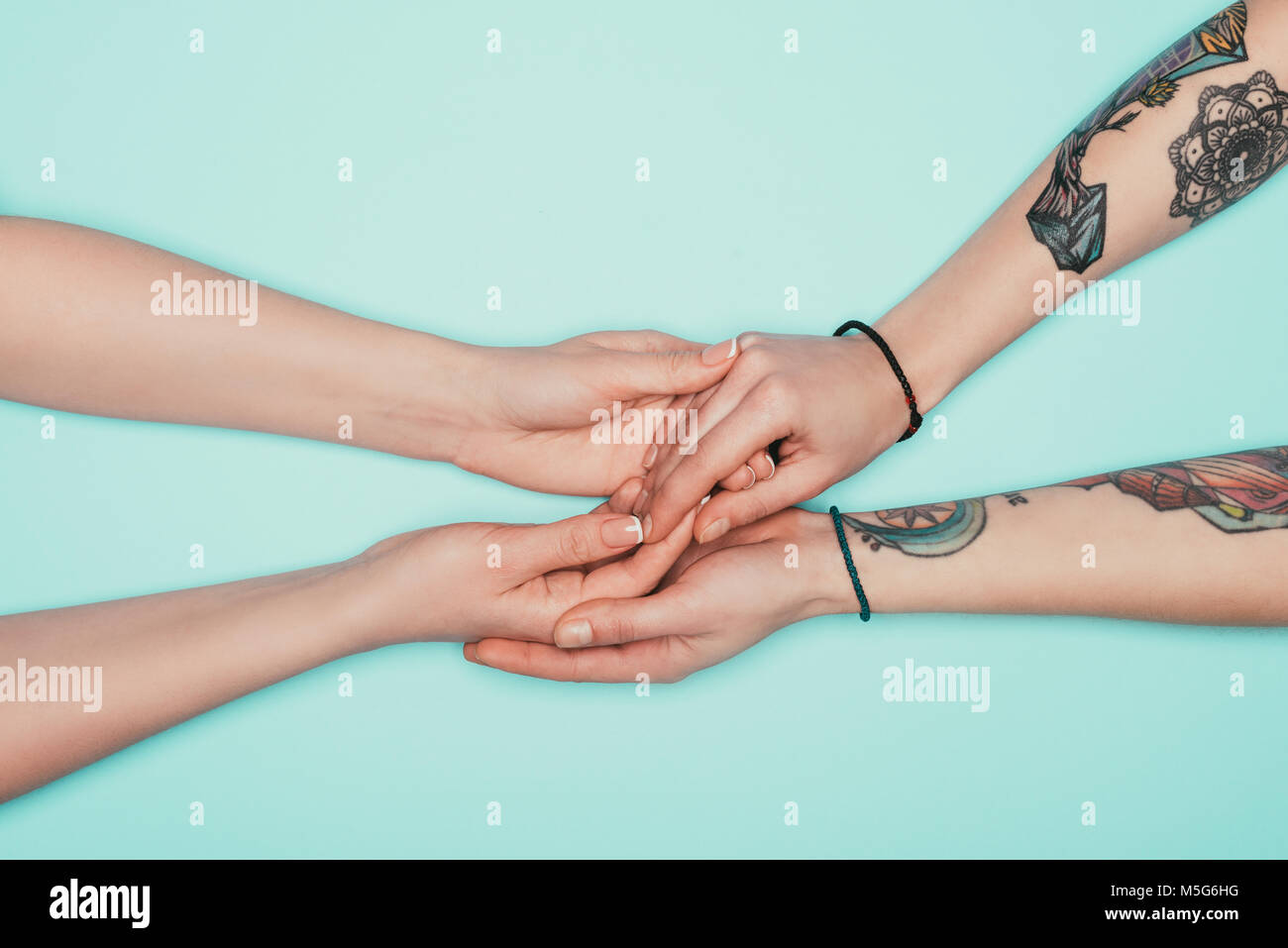 cropped shot of sensual women holding hands of each other isolated on ...