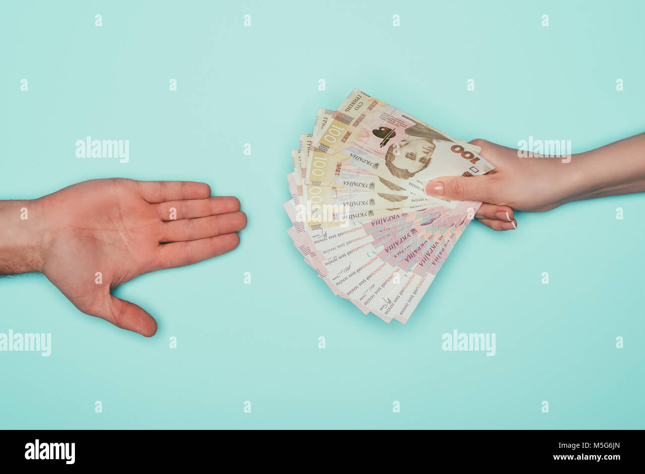 cropped shot of people passing cash isolated on turquoise Stock Photo ...
