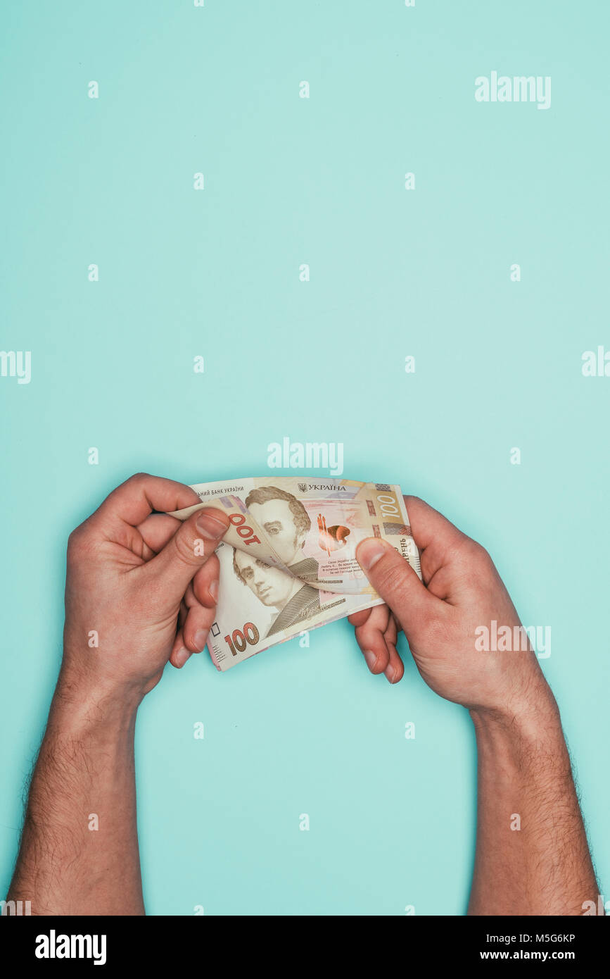cropped shot of man counting money isolated on turquoise Stock Photo ...