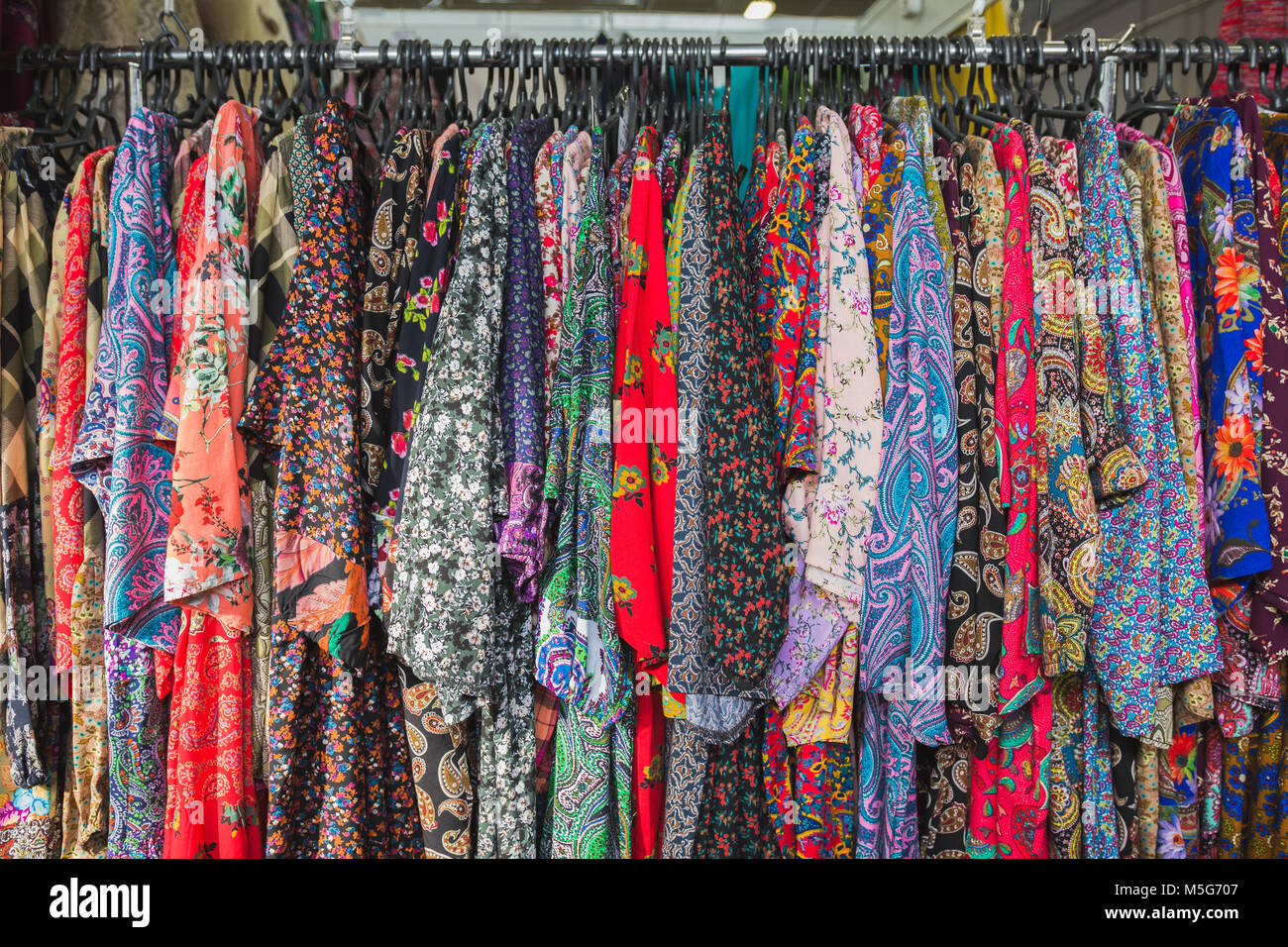 Close up colourful clothes hang on clothes rack in clothing store Stock ...