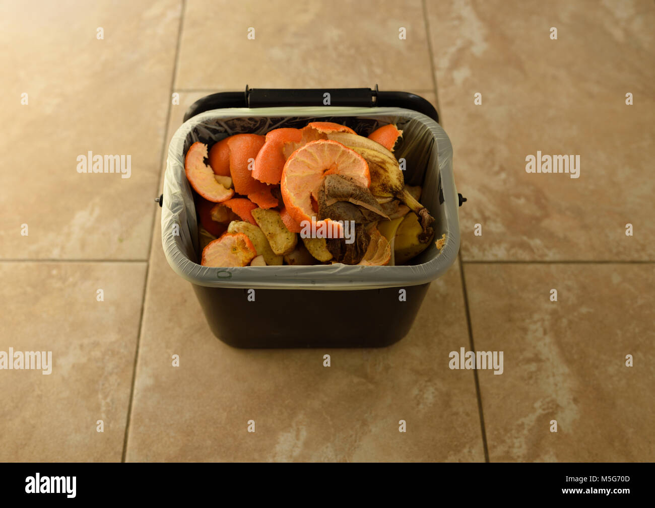 Indoor kitchen waste for compositing lid open, with full recycling bag ...