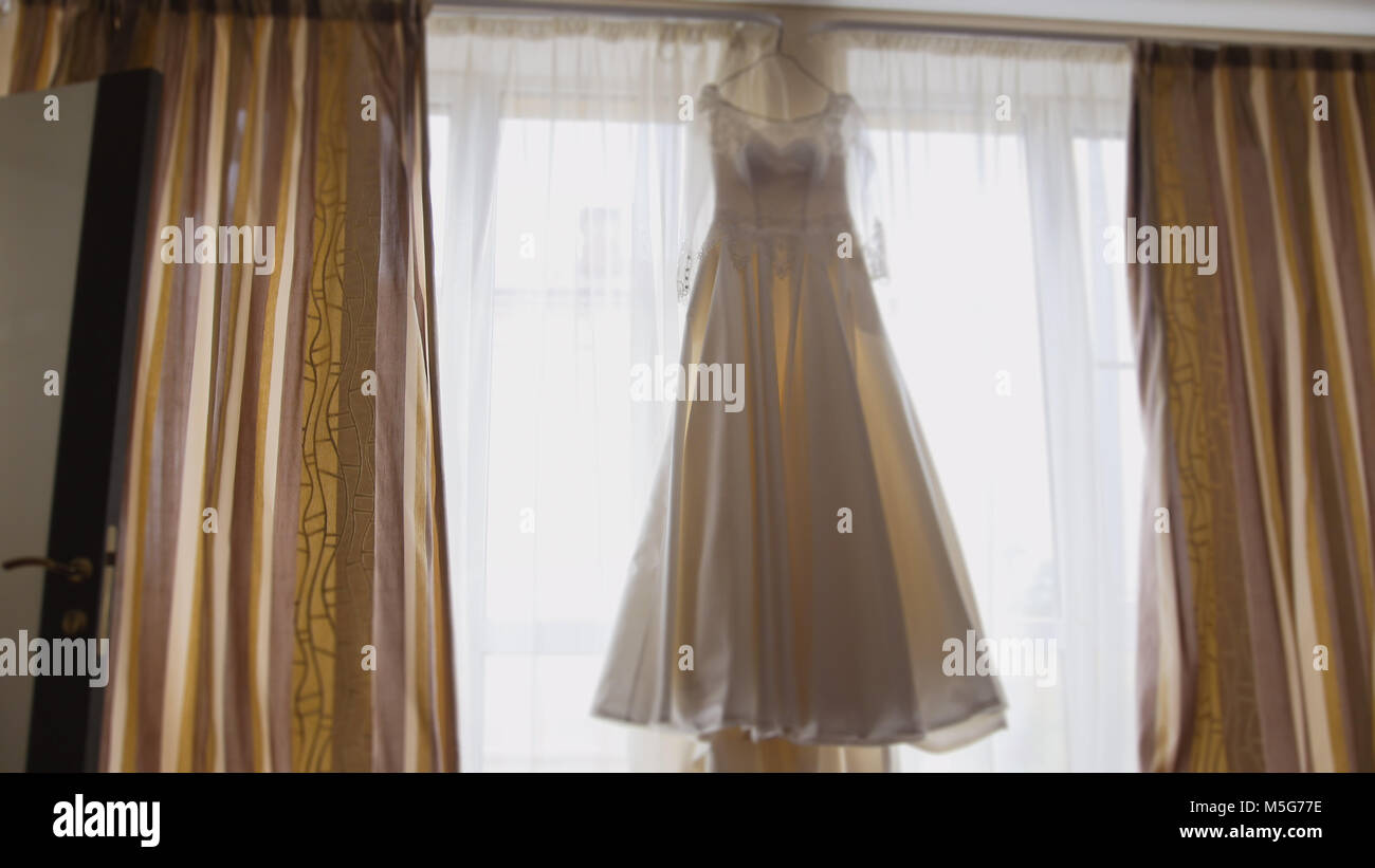 Beautiful wedding dress on window in bride's room Stock Photo - Alamy