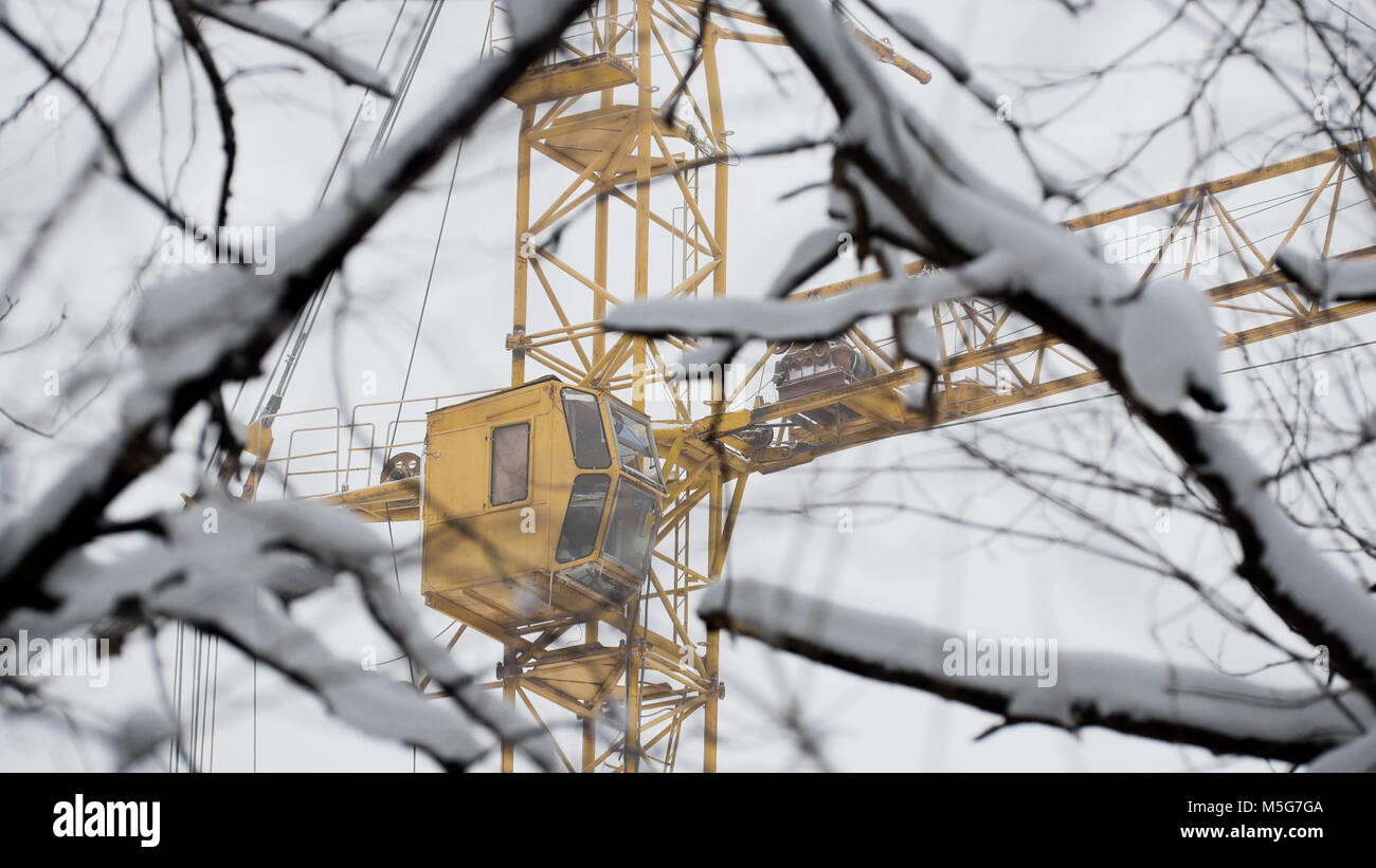 Yellow construction crane in snow winter, close up Stock Photo - Alamy