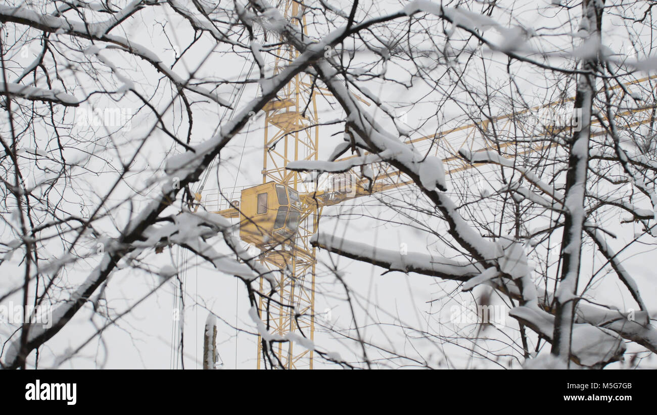 Yellow construction crane in snow winter Stock Photo - Alamy