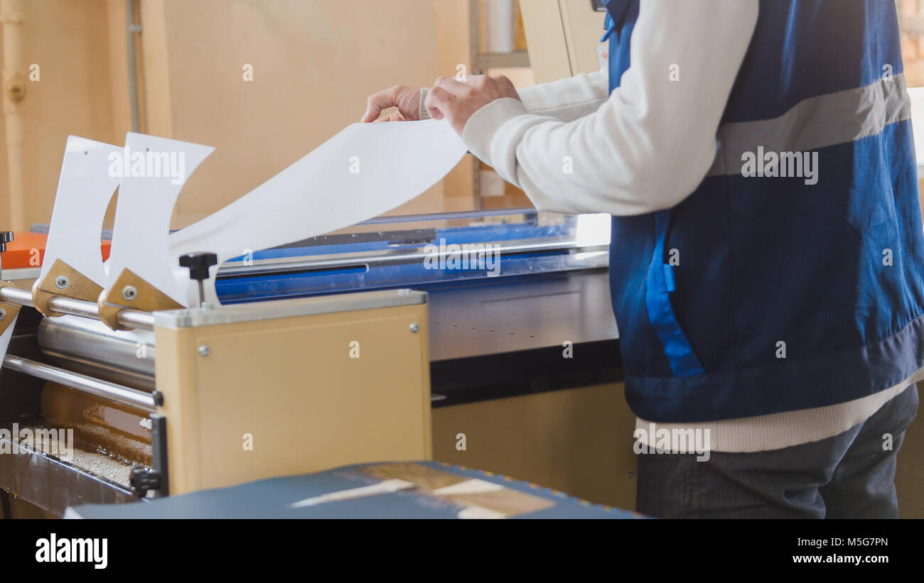 The typography worker pulls the paper from the machine Stock Photo - Alamy