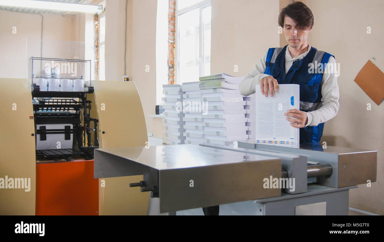 The print operator looks at the finished product Stock Photo - Alamy