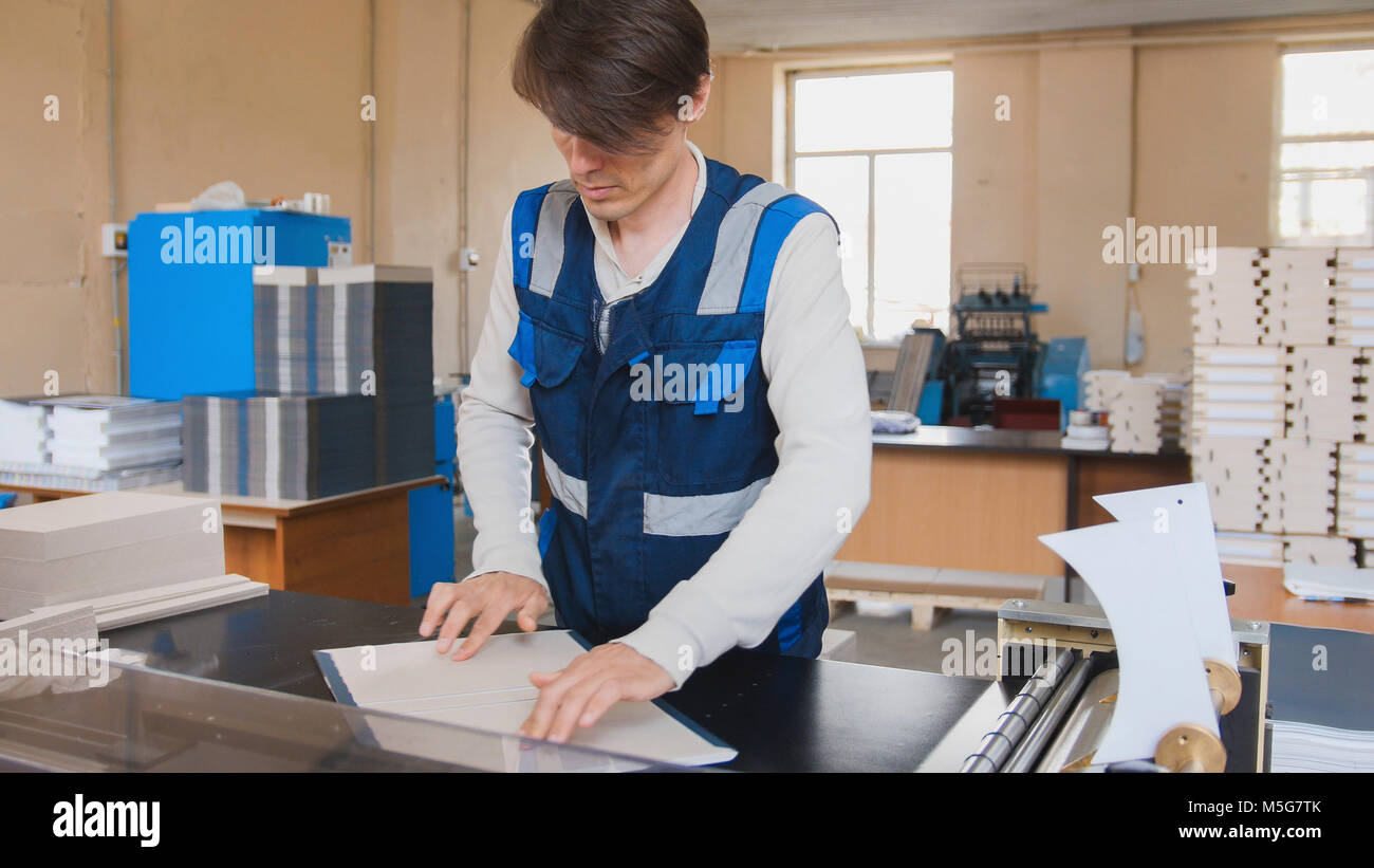 Printing process - worker inserts paper sheets Stock Photo - Alamy