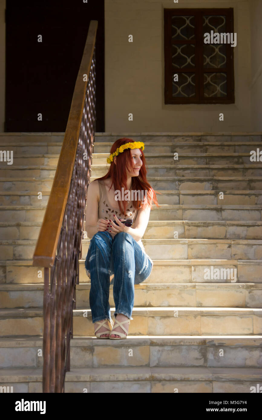 A girl sits on the stairs and looks out the window Stock Photo - Alamy