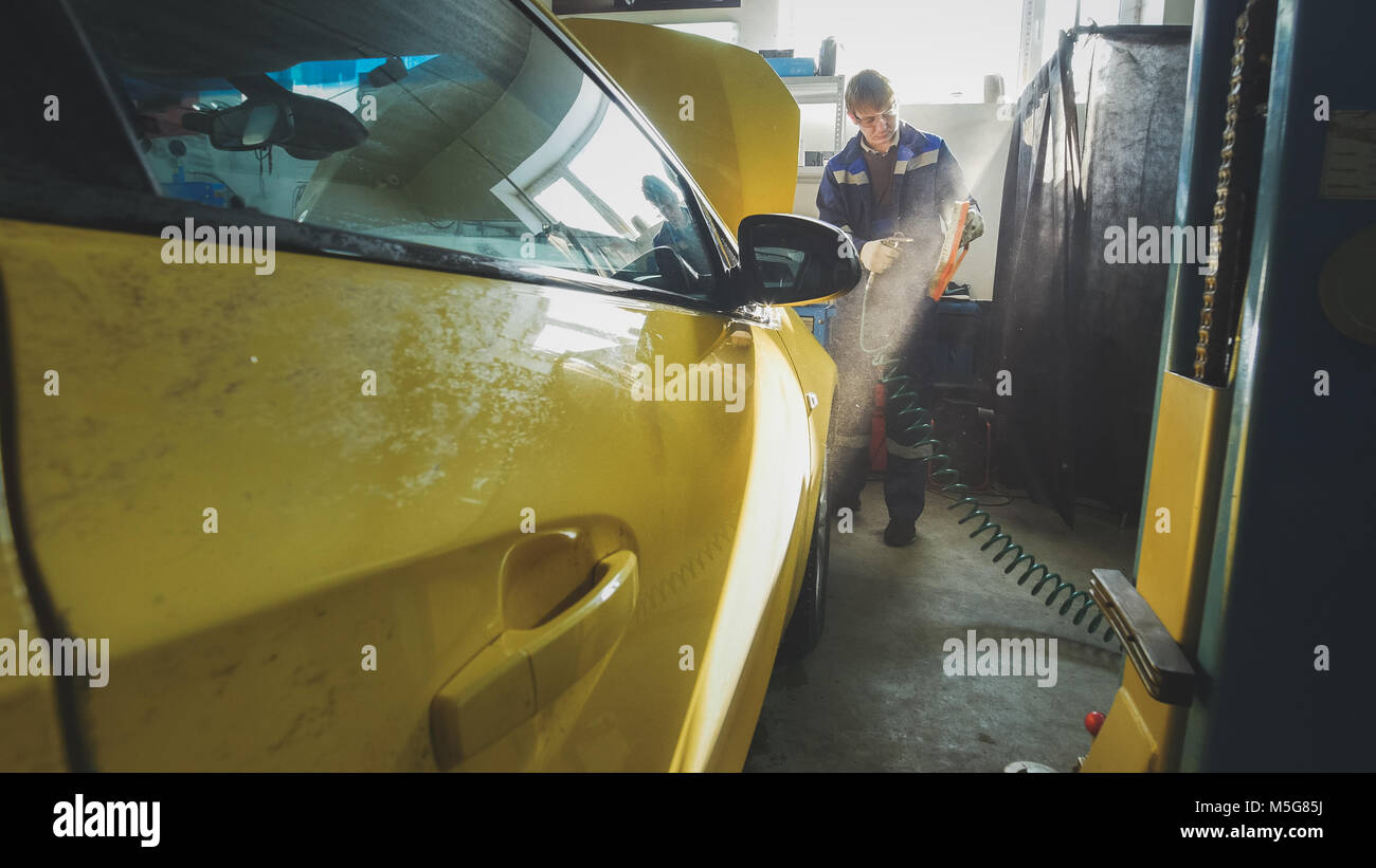 Car auto service - mechanic unscrews detail of car in hood Stock Photo ...