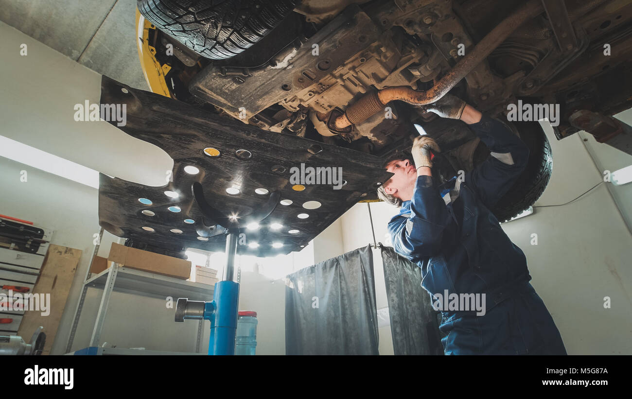 Worker mechanic checks the bottom of car - automobile service Stock ...