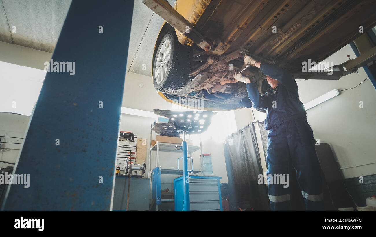 Mechanic checks bottom of the car in Garage mechanical workshop ...