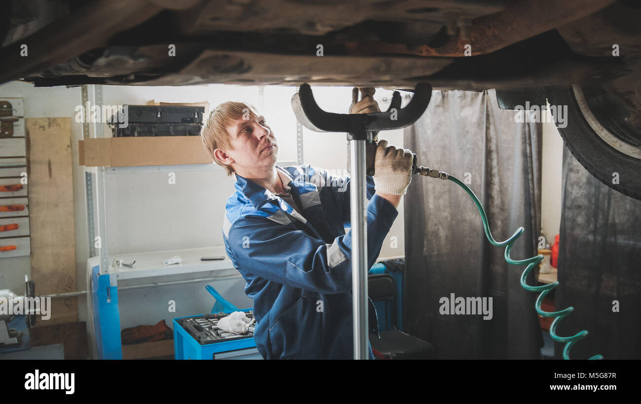 Man caucasian worker - mechanic in automobile garage repairing workshop ...