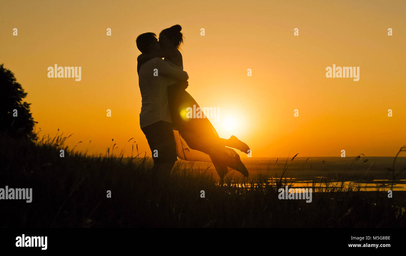 Romantic Silhouette of Man Getting Down on his Knee and Proposing to ...