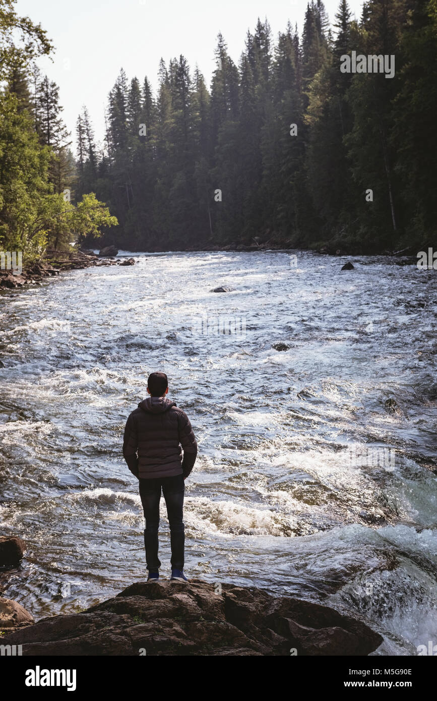 Man standing near waterfall Stock Photo - Alamy