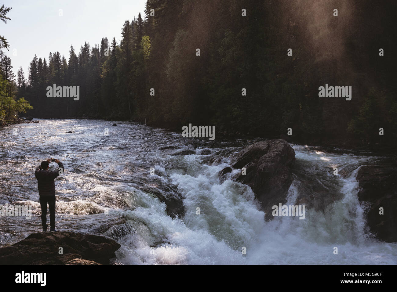 Man standing near waterfall Stock Photo - Alamy