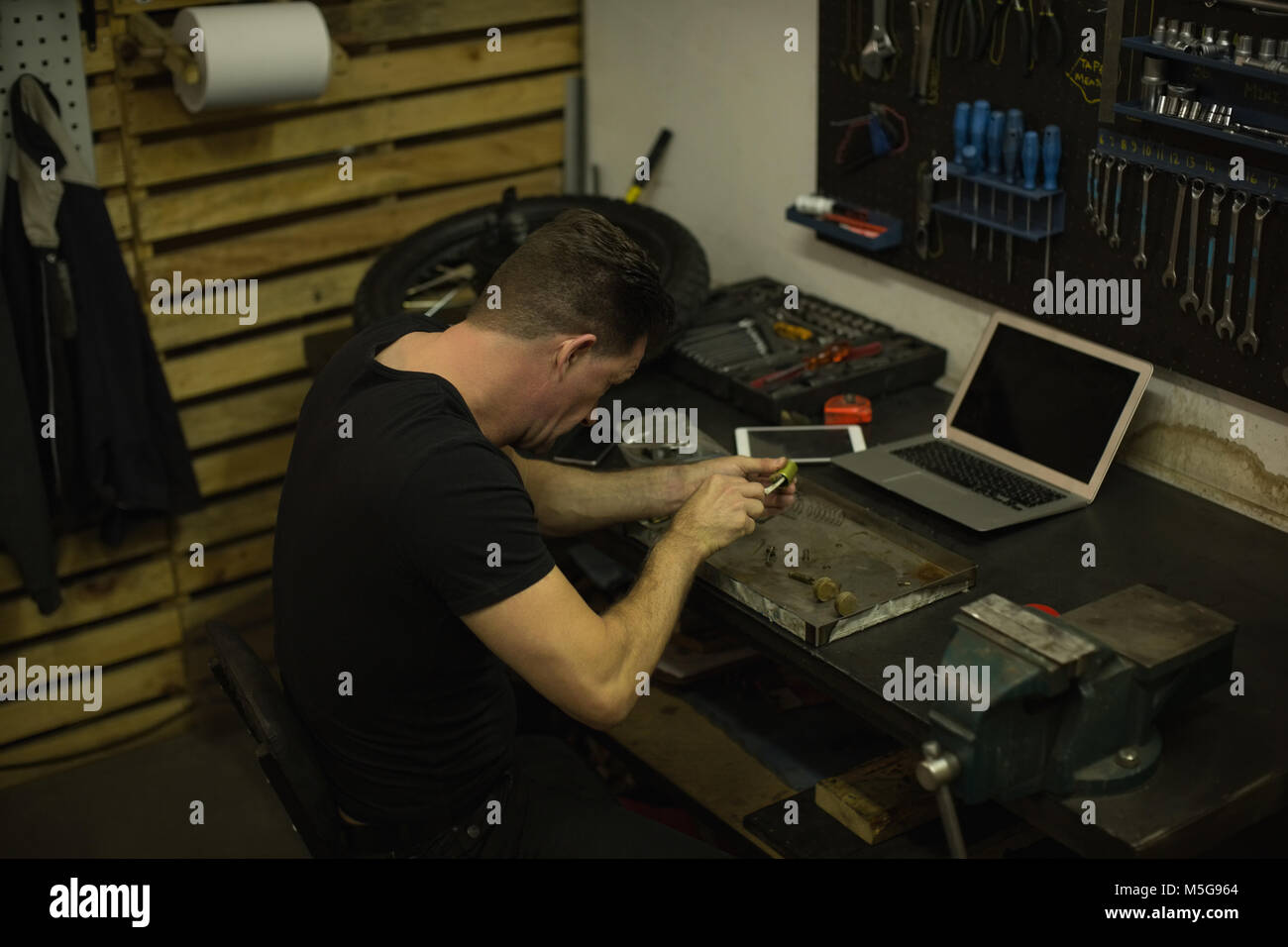 Mechanic working at garage Stock Photo - Alamy