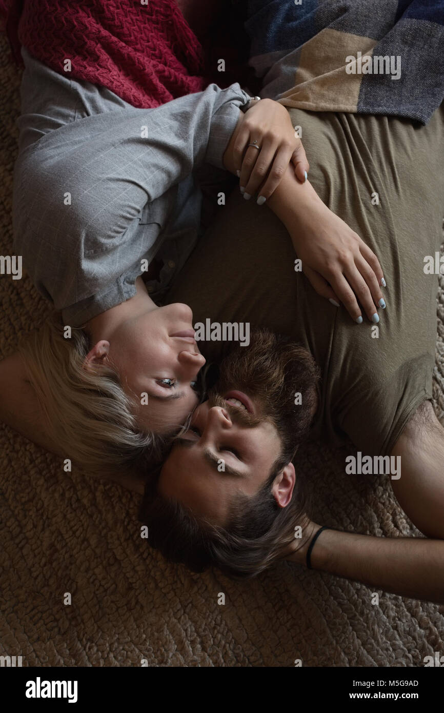Couple relaxing on floor rug Stock Photo - Alamy