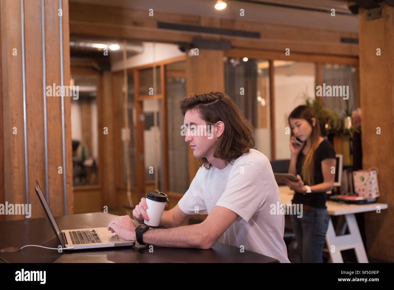 Male executive using laptop in office Stock Photo - Alamy