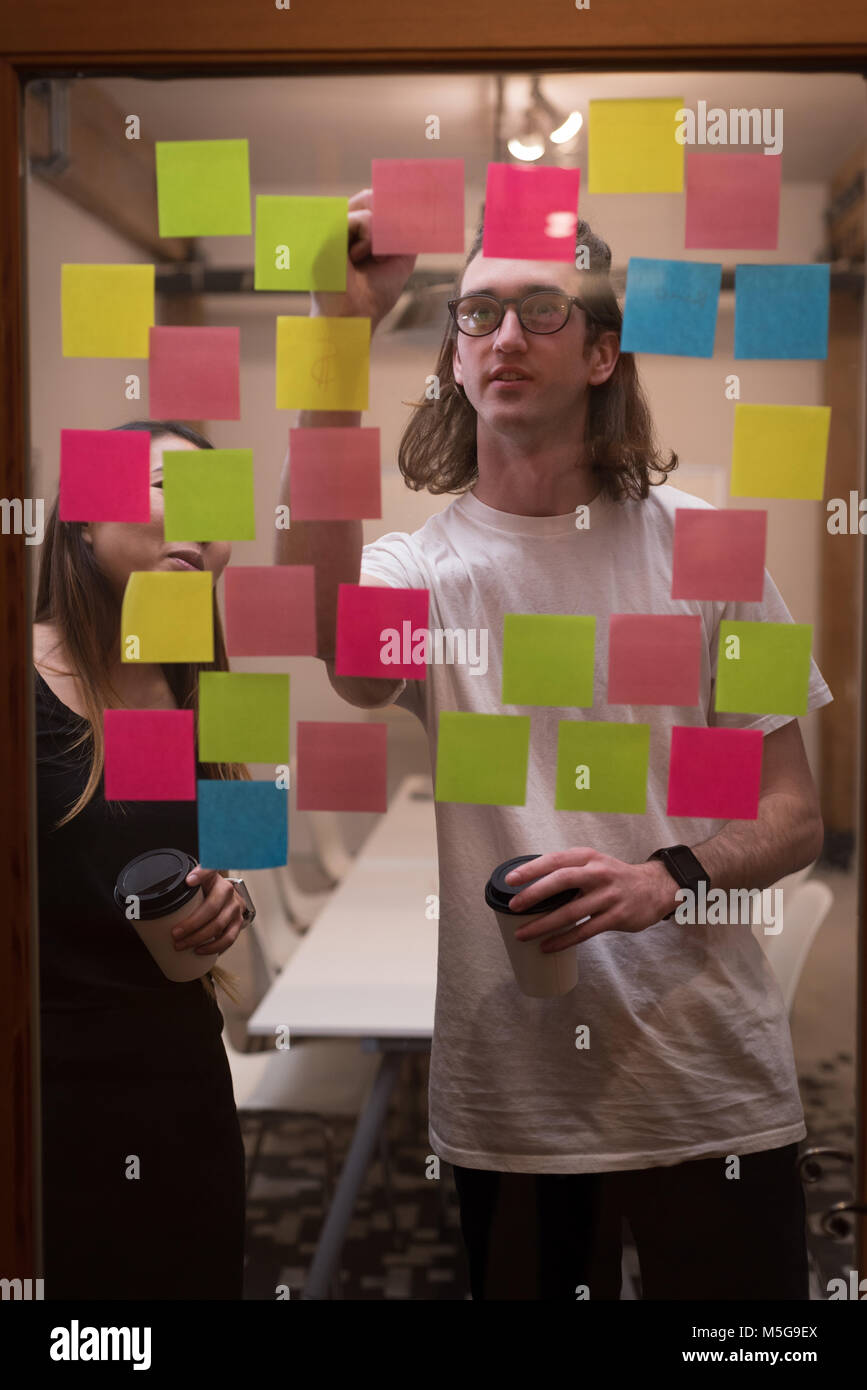 Business colleagues writing on sticky notes Stock Photo - Alamy