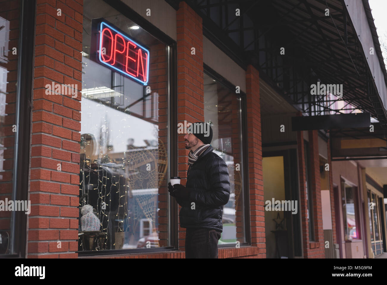 Man looking at window display of shop Stock Photo - Alamy