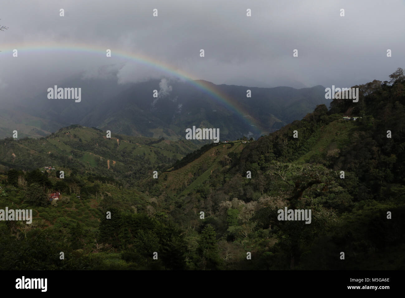 Rainbow over hills farmland Costa Rica Stock Photo - Alamy
