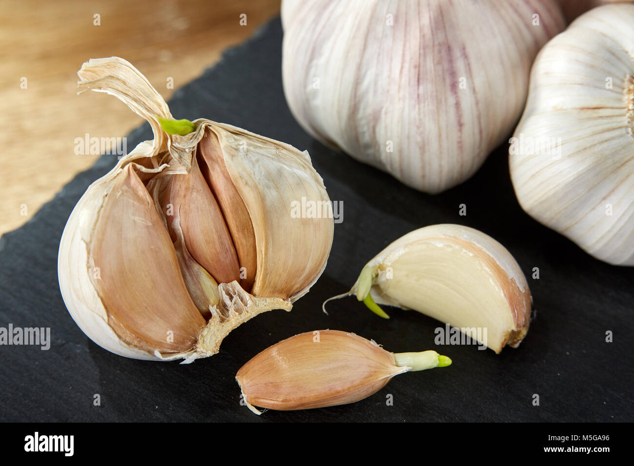 Garlic on flat black piece of board. Close-up, shallow depth of field ...
