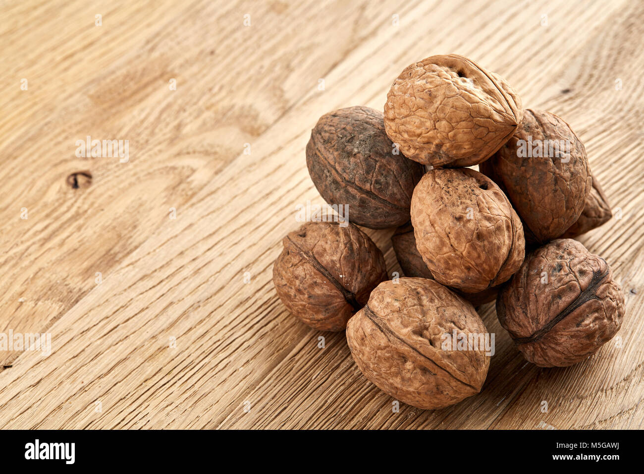 A stack of hard shells of walnuts piled together on light grey fabric ...