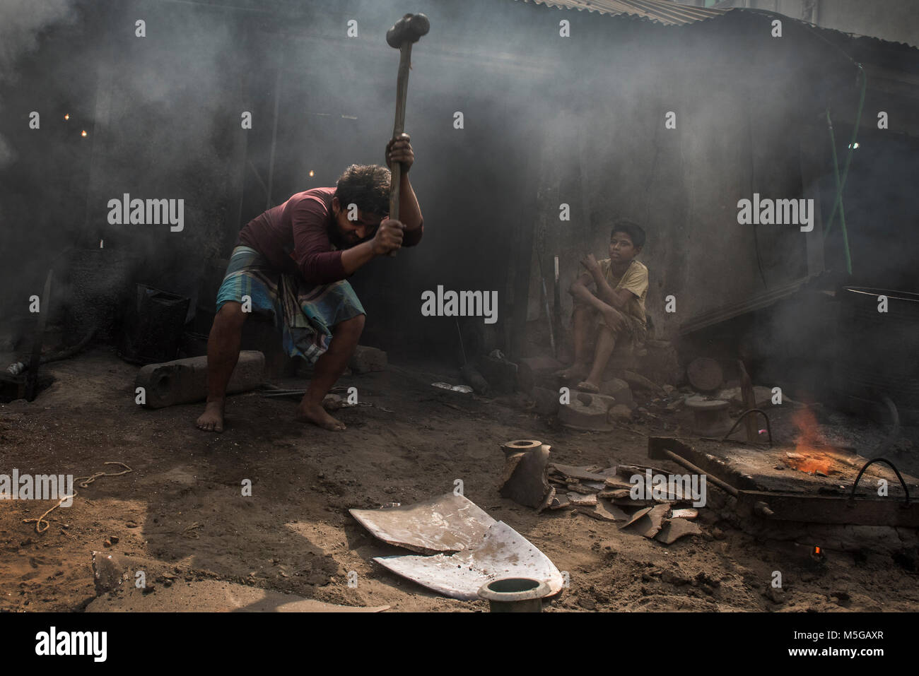 A young workers in dockyard. Bangladeshi laborers works on a ferry ...