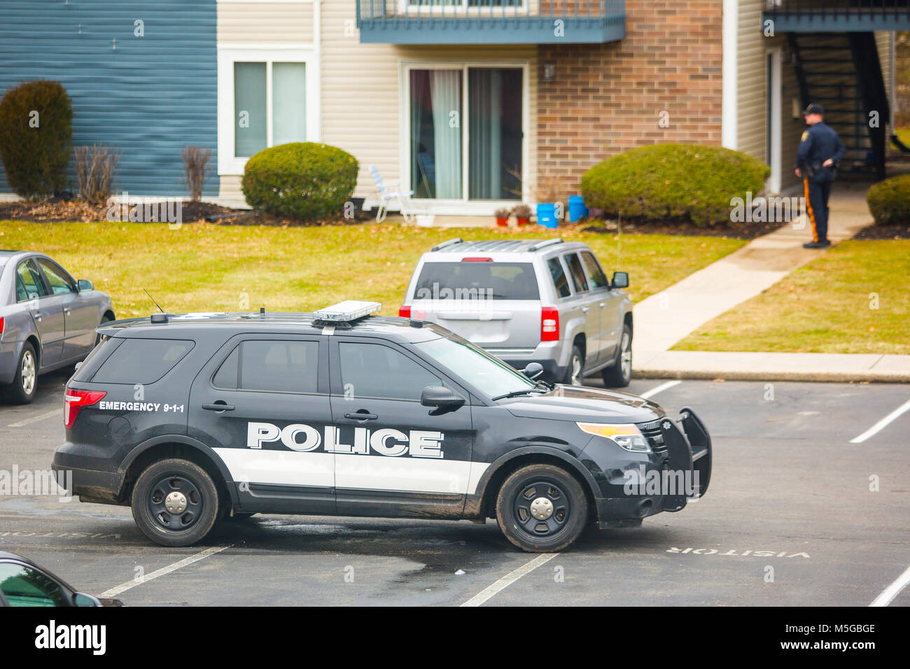 Police car parked in neighborhood with policeman outside Stock Photo ...