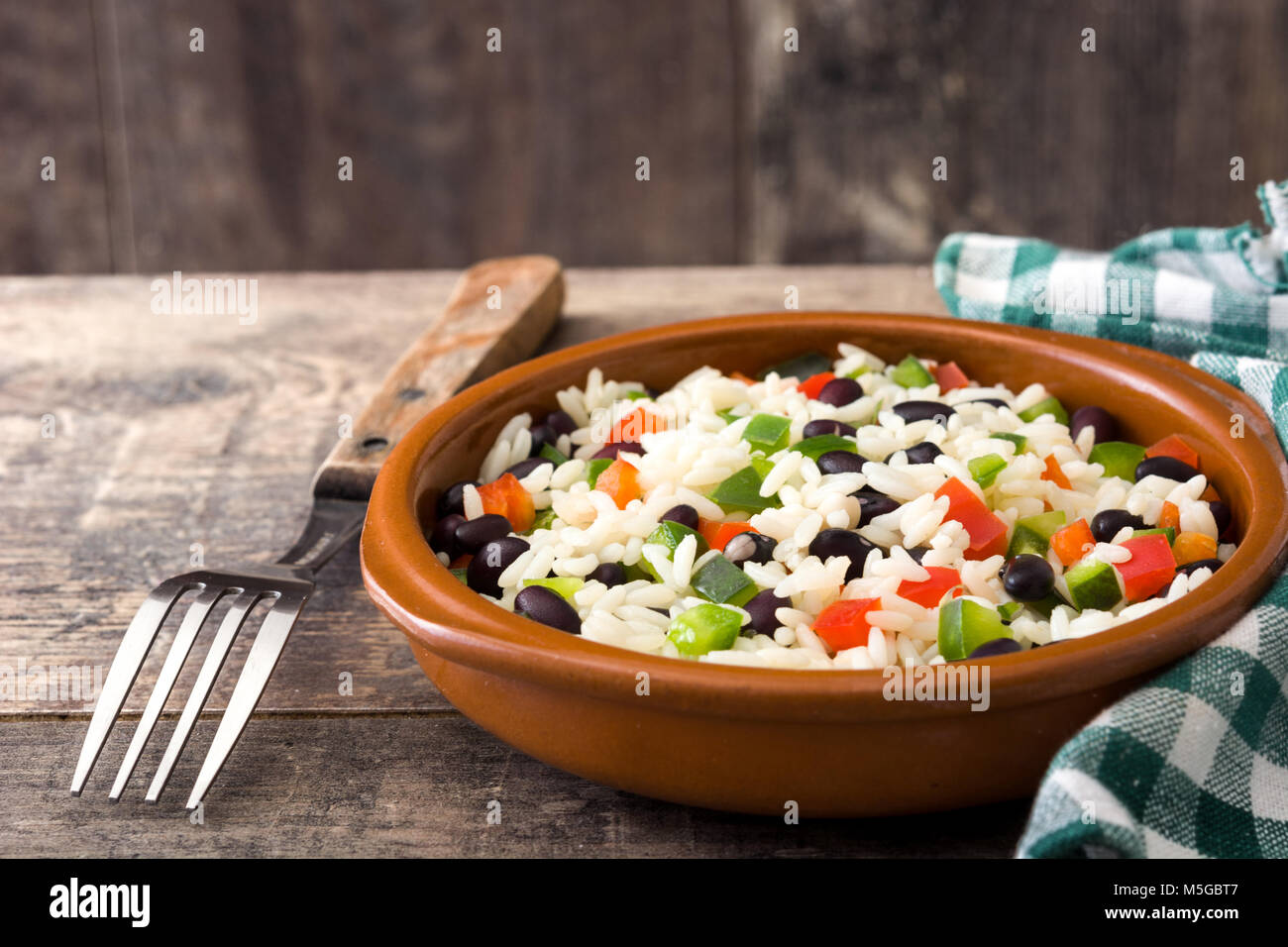 Traditional cuban rice, black beans and pepper on wooden table ...