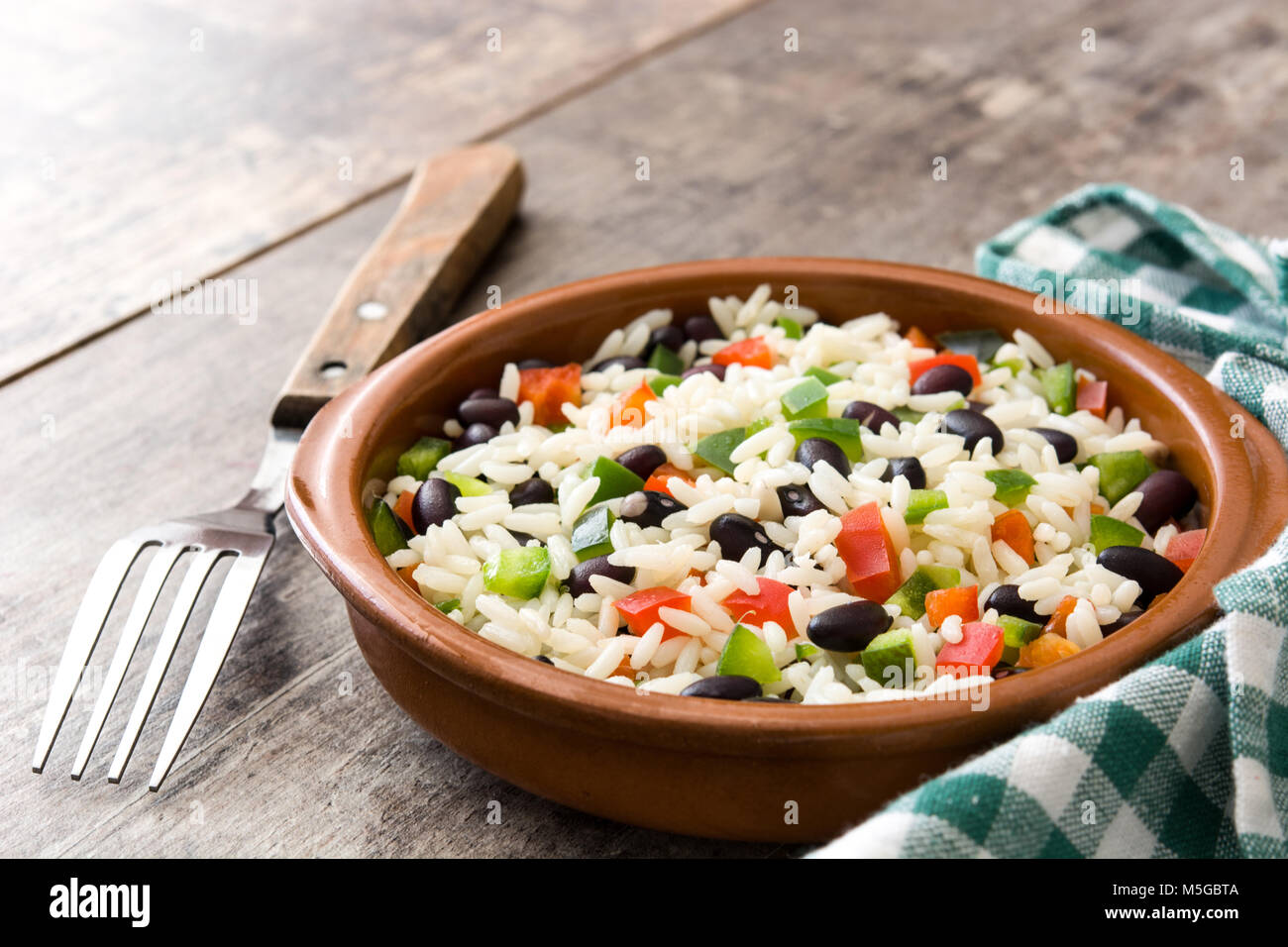 Traditional cuban rice, black beans and pepper on wooden table ...