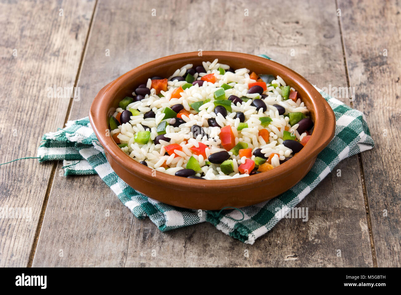 Traditional cuban rice, black beans and pepper on wooden table ...