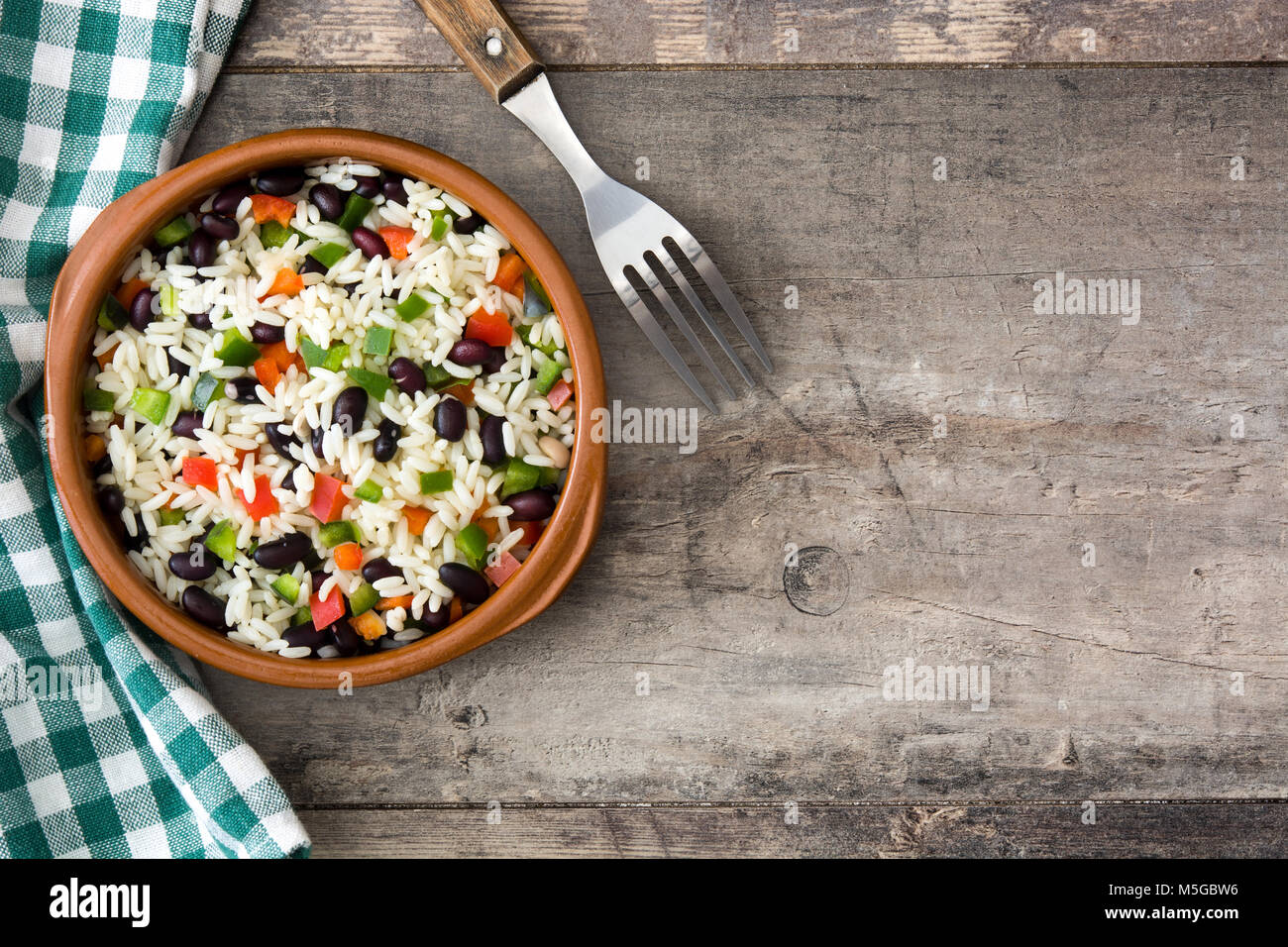 Traditional cuban rice, black beans and pepper on wooden table ...