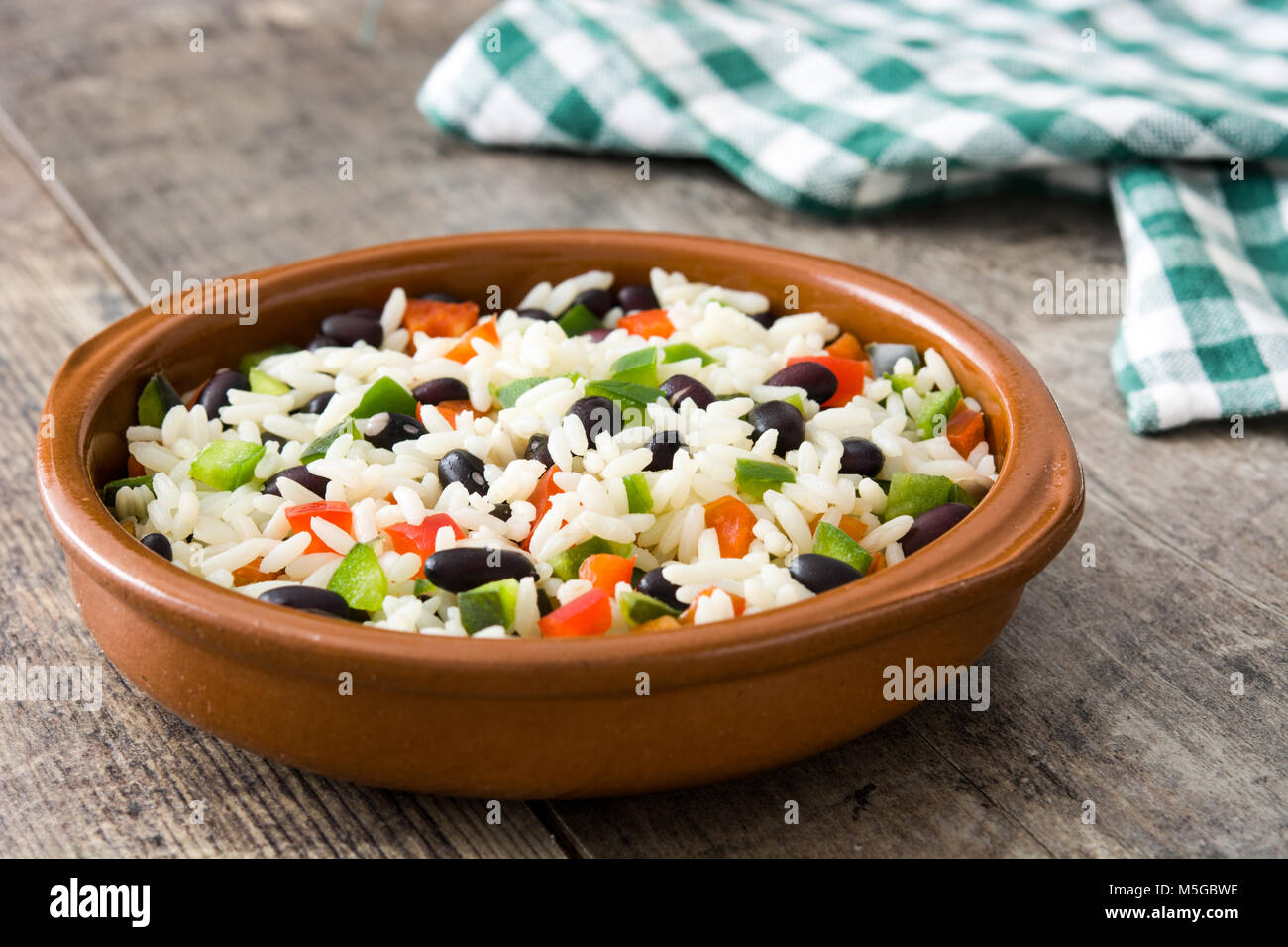 Traditional cuban rice, black beans and pepper on wooden table ...