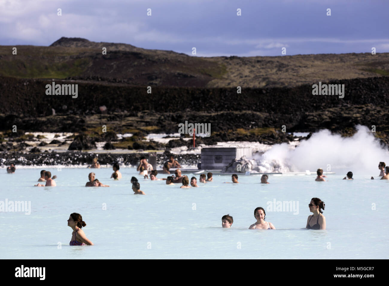 Visitors relax in the geothermal spa of the Blue Lagoon with Svartsengi ...