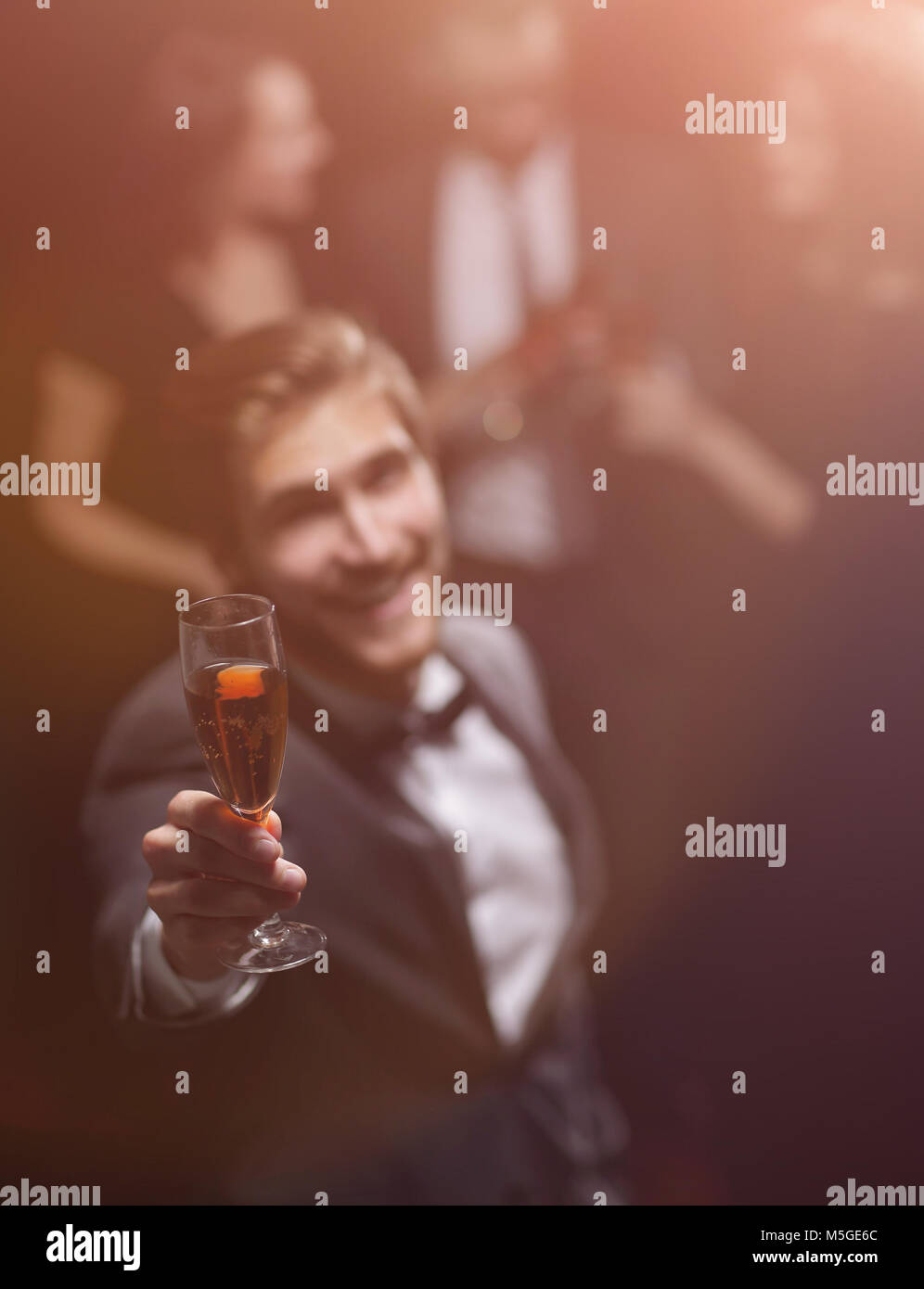 stylish young man raising his glass in a toast Stock Photo - Alamy