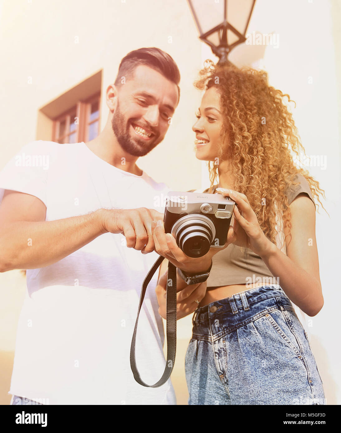 Portrait of young friends walking looking at the photos Stock Photo - Alamy