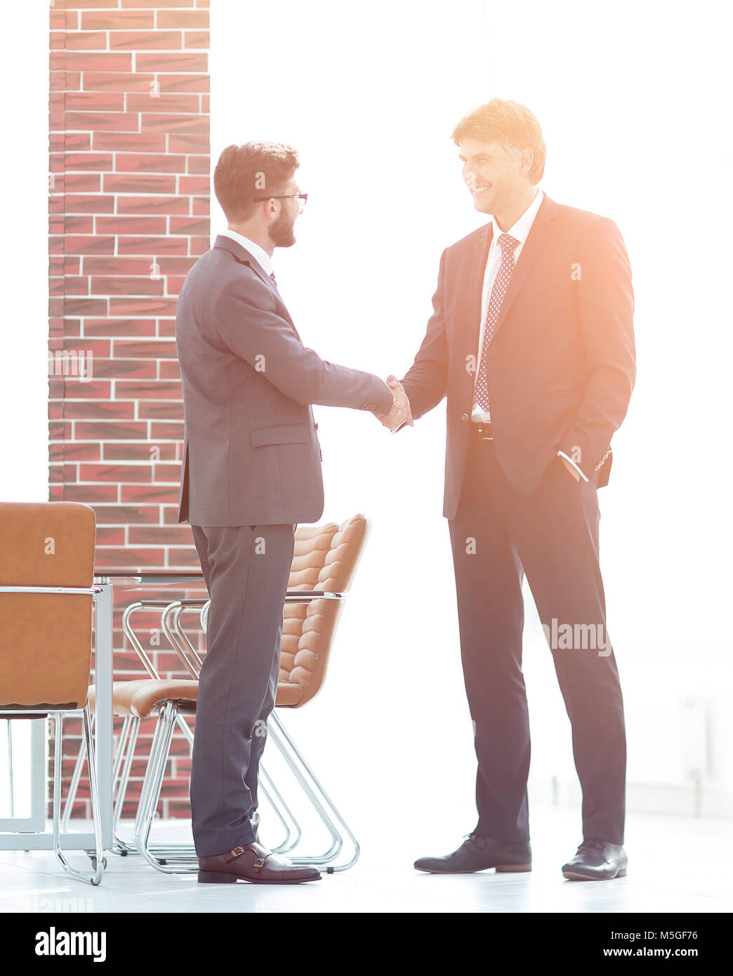Two business people shake hands in the office Stock Photo - Alamy