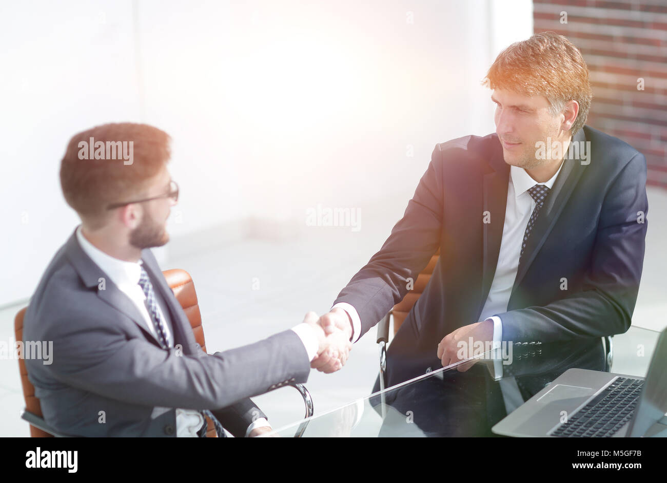 Business people handshake, sitting at the table Stock Photo - Alamy