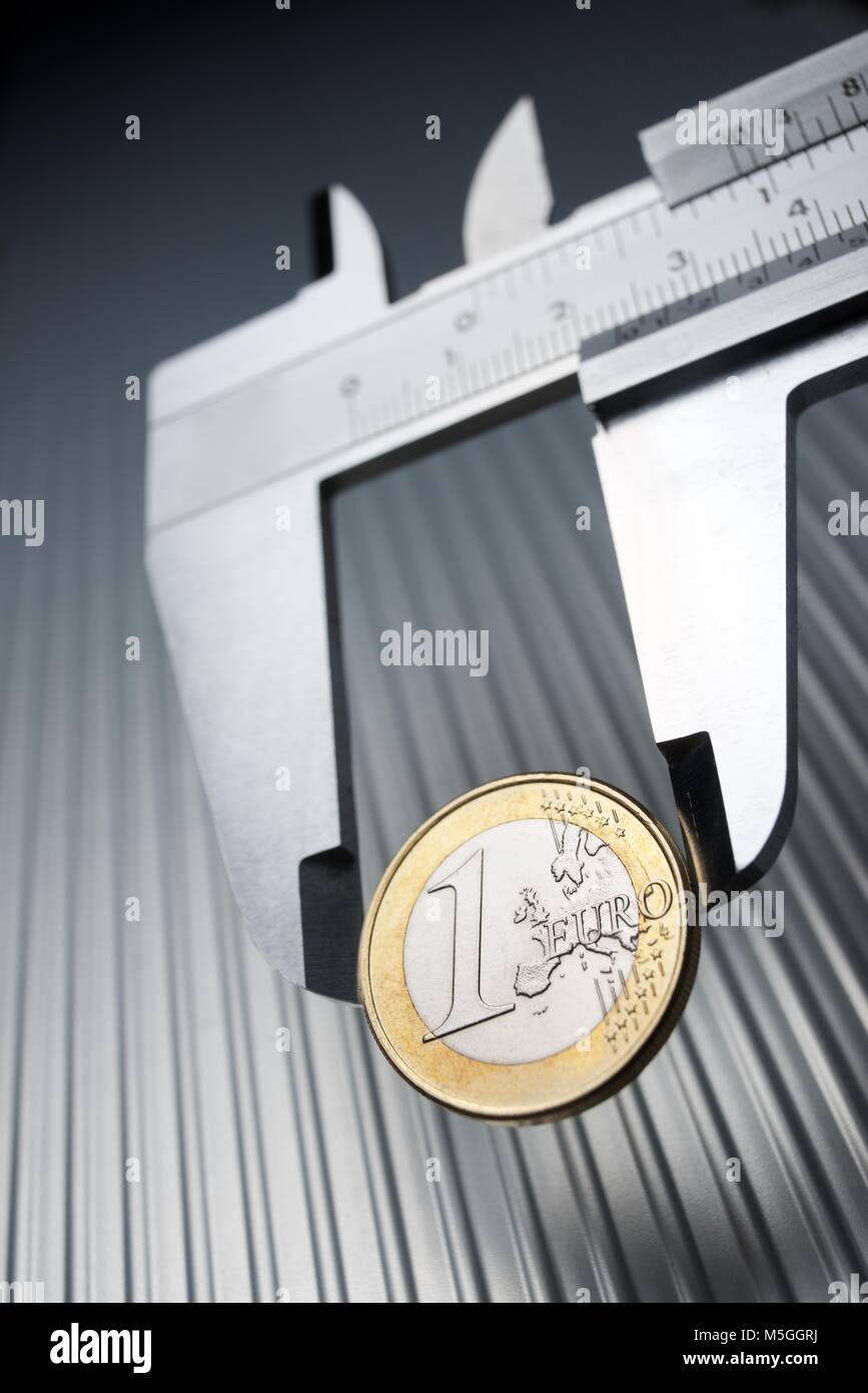 metal gauge measuring a one euro coin on a metal surface Stock Photo ...