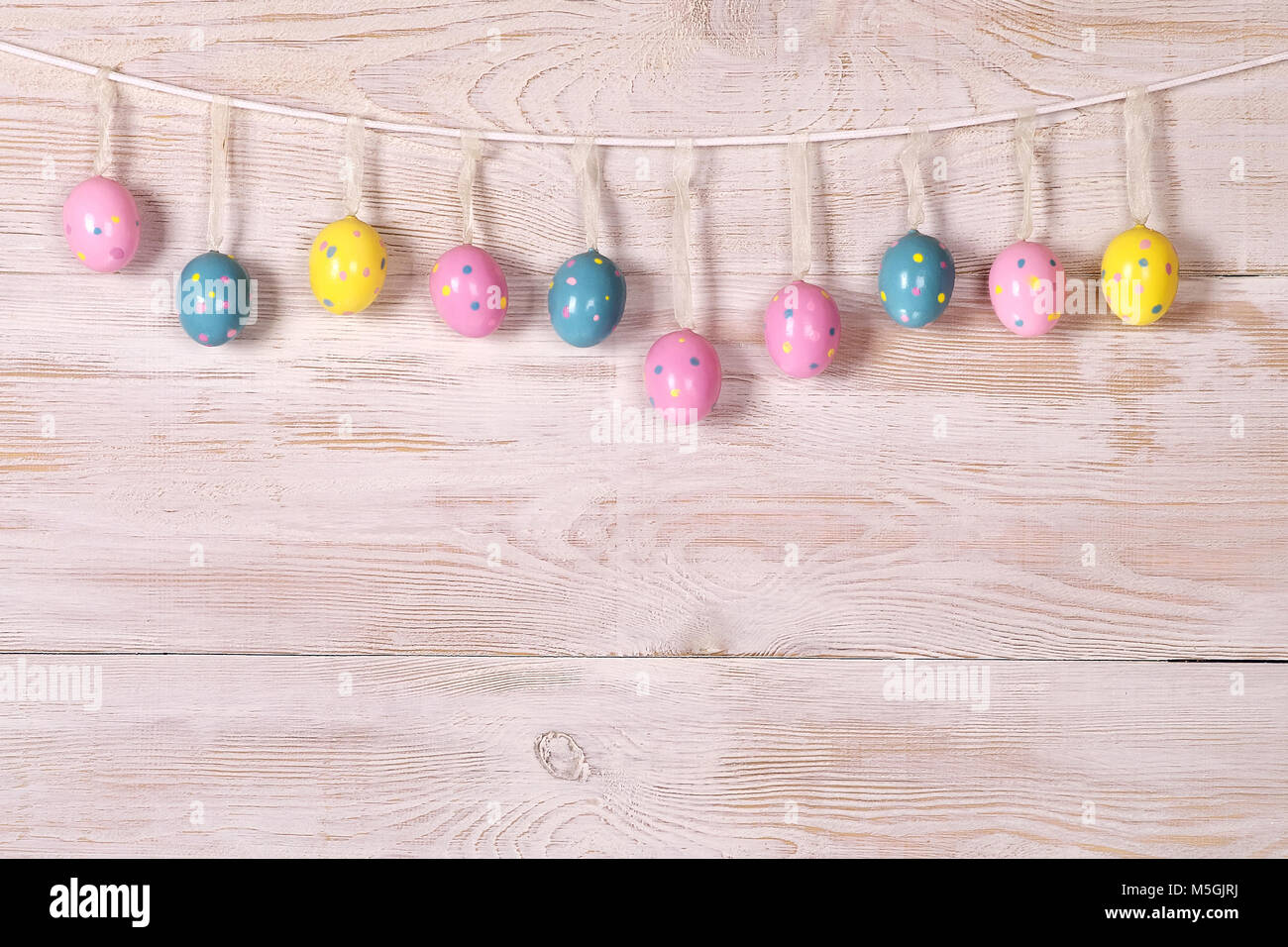 colorful Easter eggs on a rope. wooden wall. vivid colors of Easter ...
