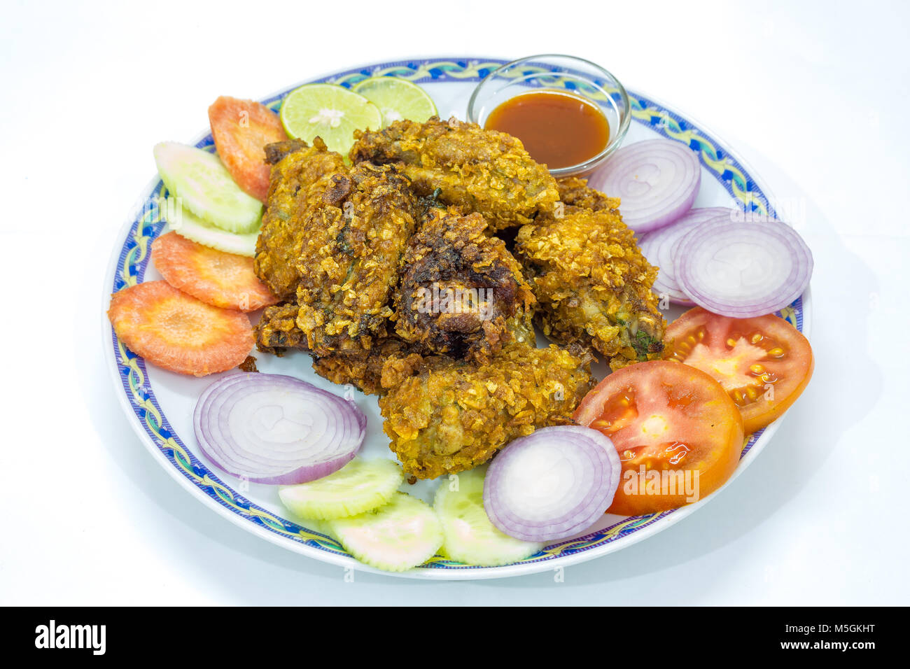 Deep fried spicy chicken pakora served with tomato sauce and sliced ...