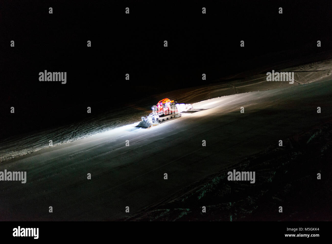 An amazing view of a snowcat in the snow at the top of a ski piste at ...