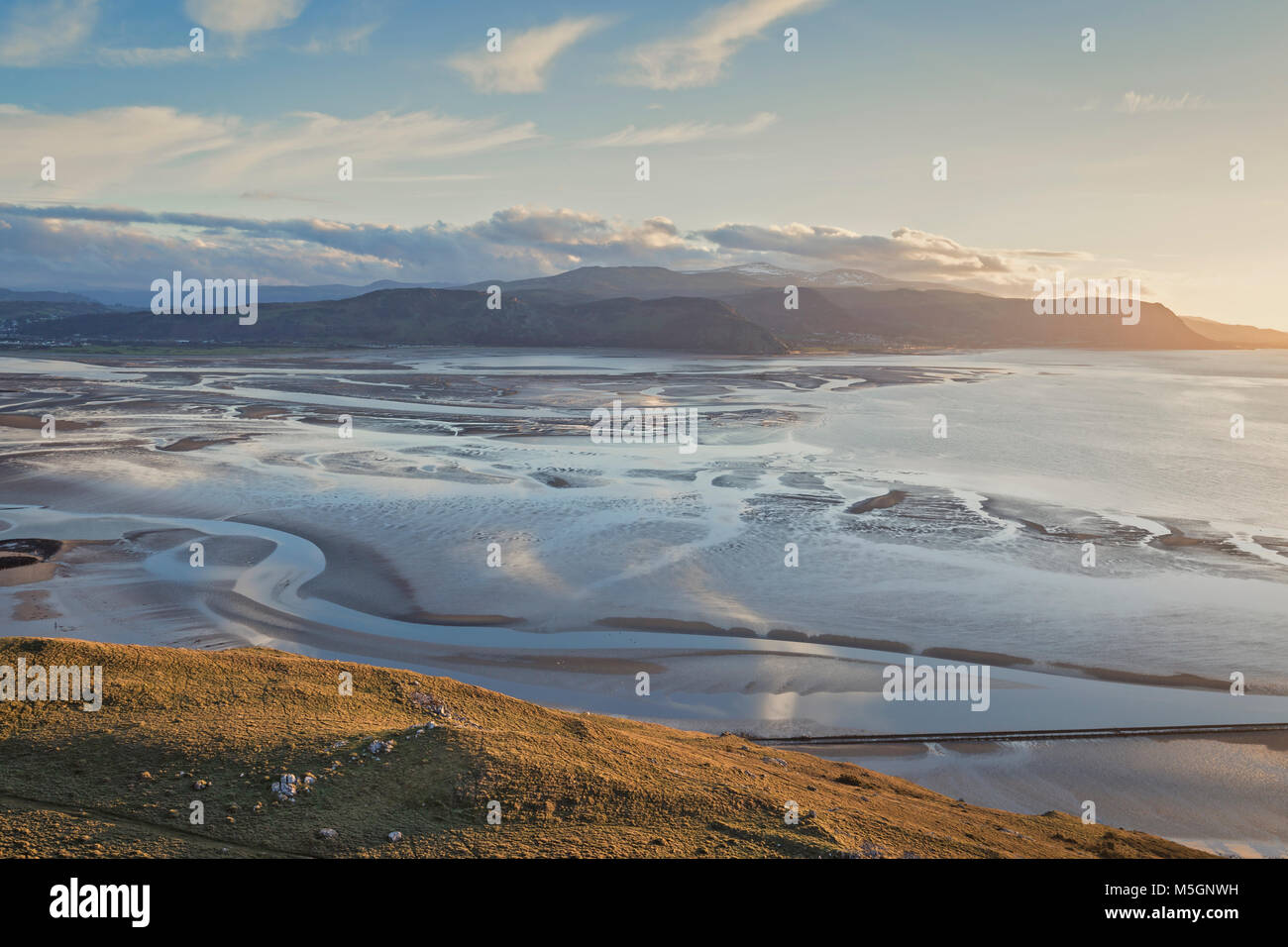 Sunset over Llandudno bay at low tide with scenic hills of Snowdonia in ...