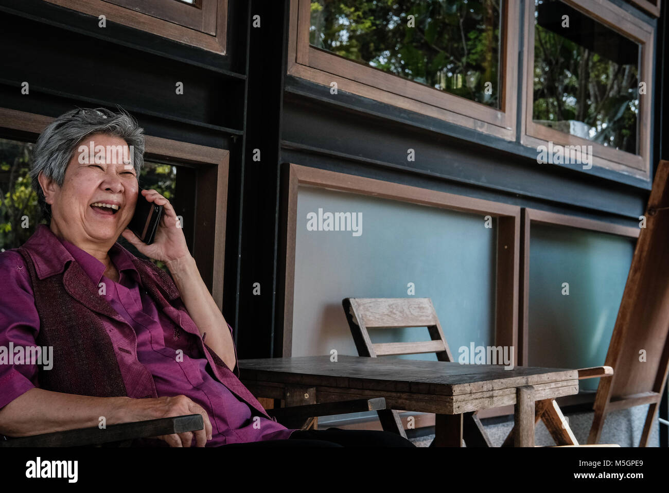 elder woman talk on mobile phone on terrace. elderly female speaking on ...