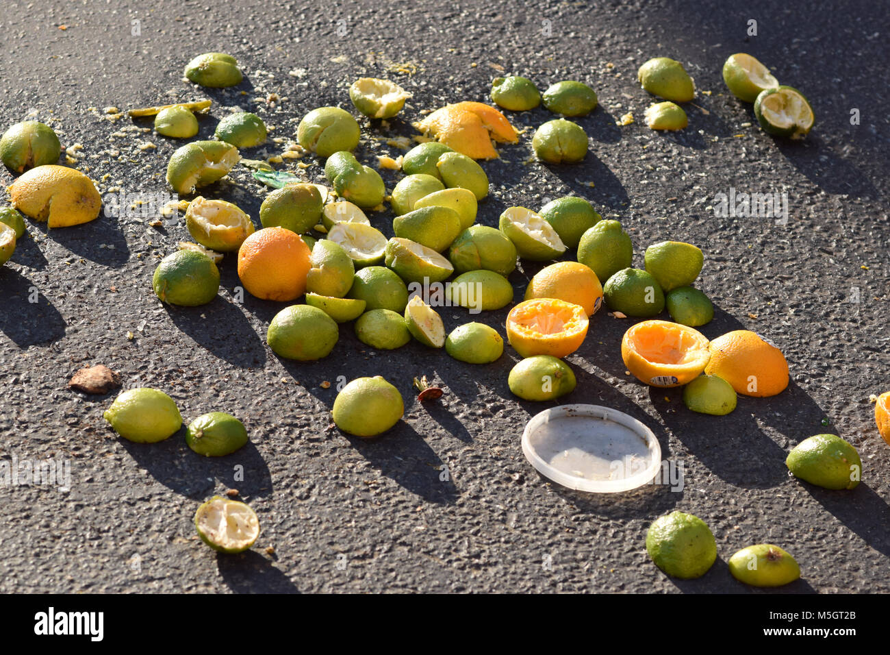 Juiced citrus rinds discarded on the asphalt Stock Photo - Alamy