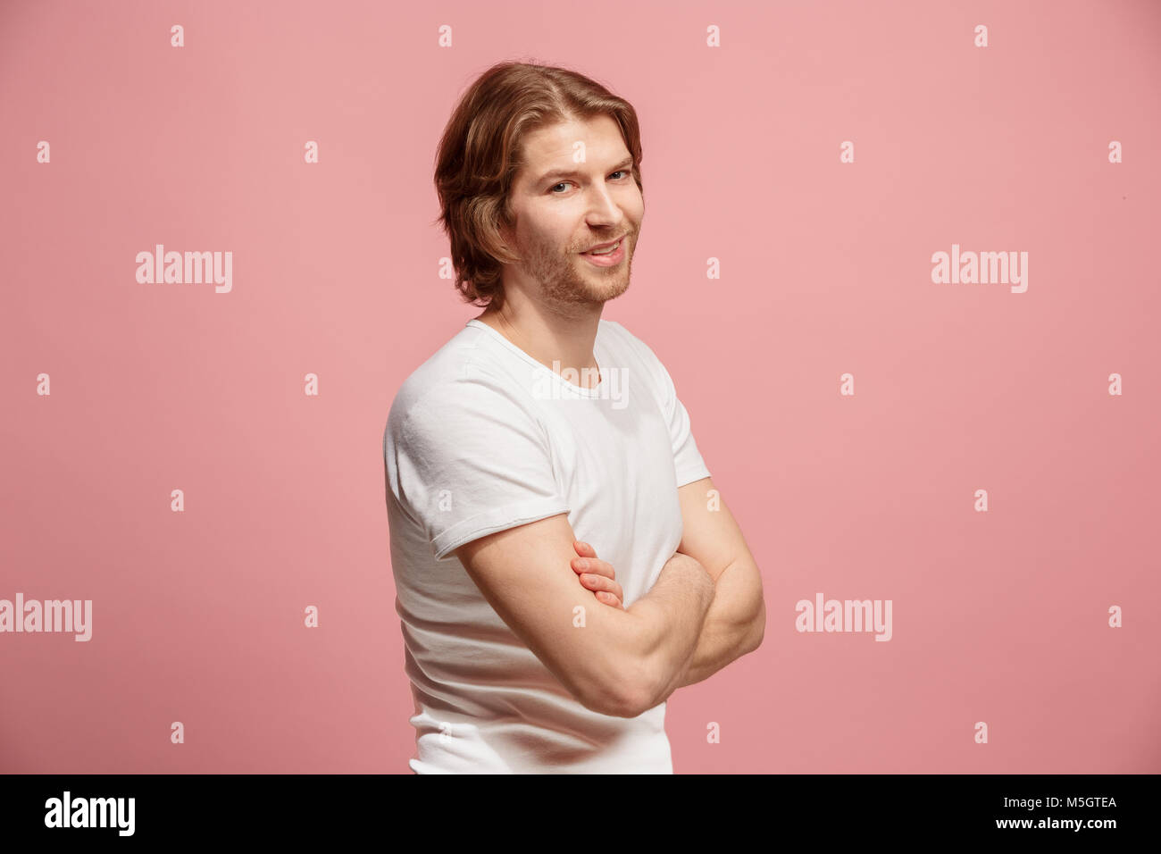 Happy business man standing and smiling isolated on pink studio ...