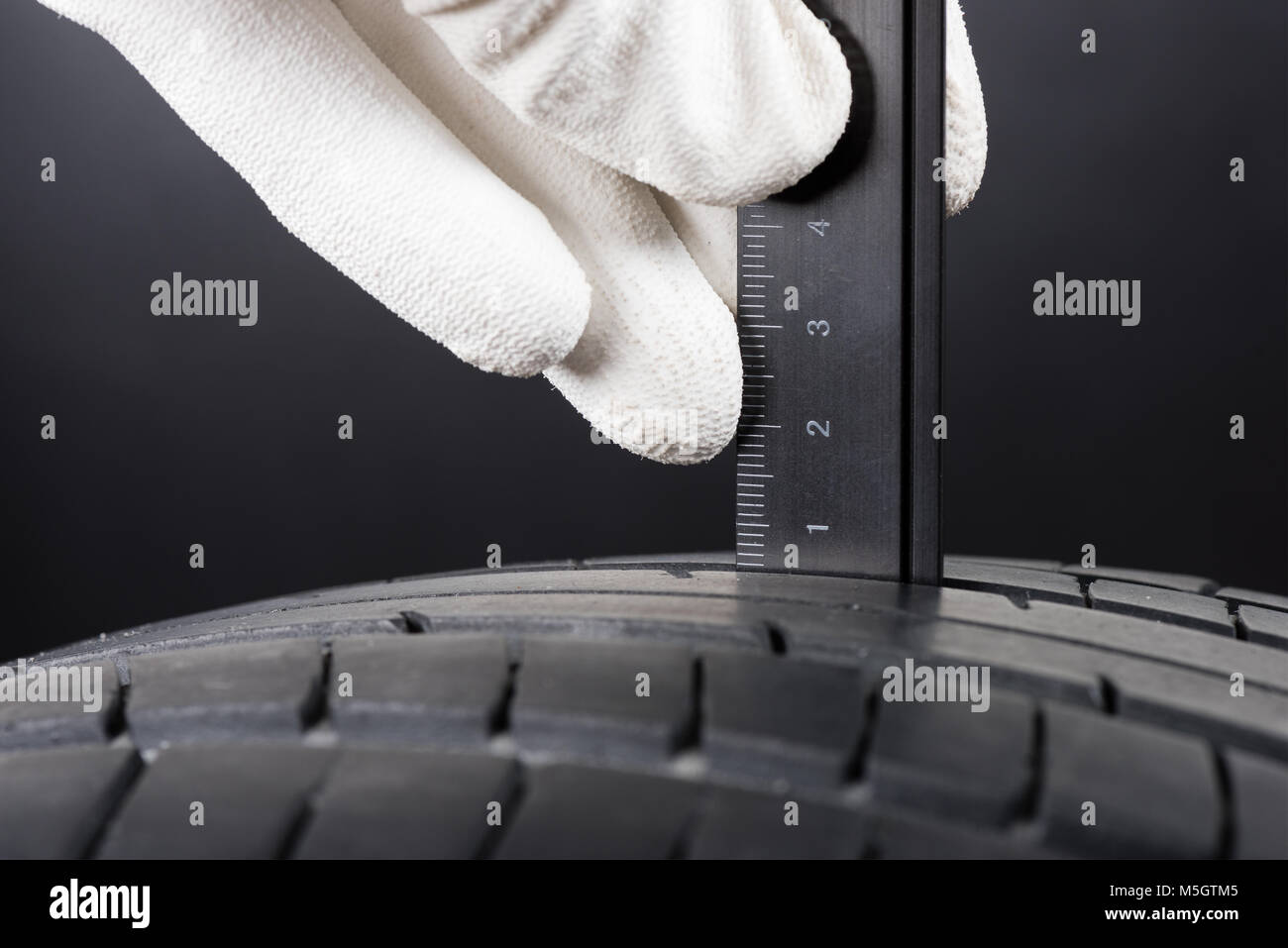 checking the depth of car tire tread Stock Photo - Alamy