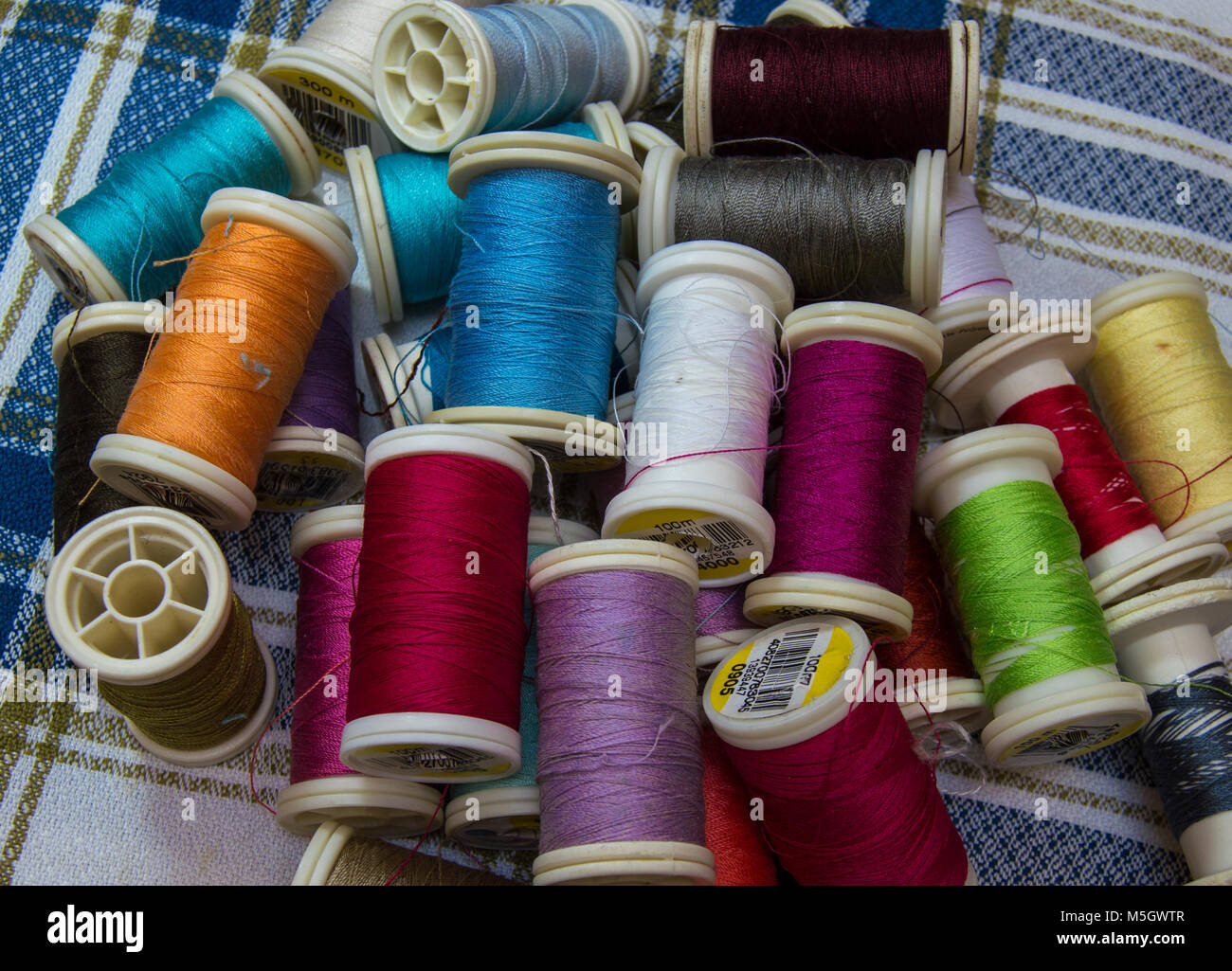 Mountain of colorful yarn spools of many colors on pretty checkered ...