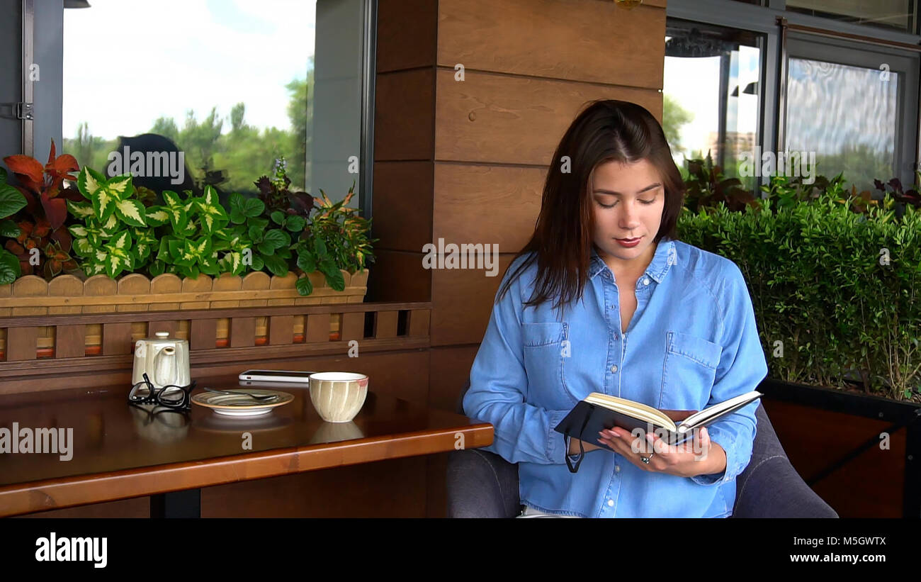 Beautiful girl reading diary at cafe Stock Photo - Alamy